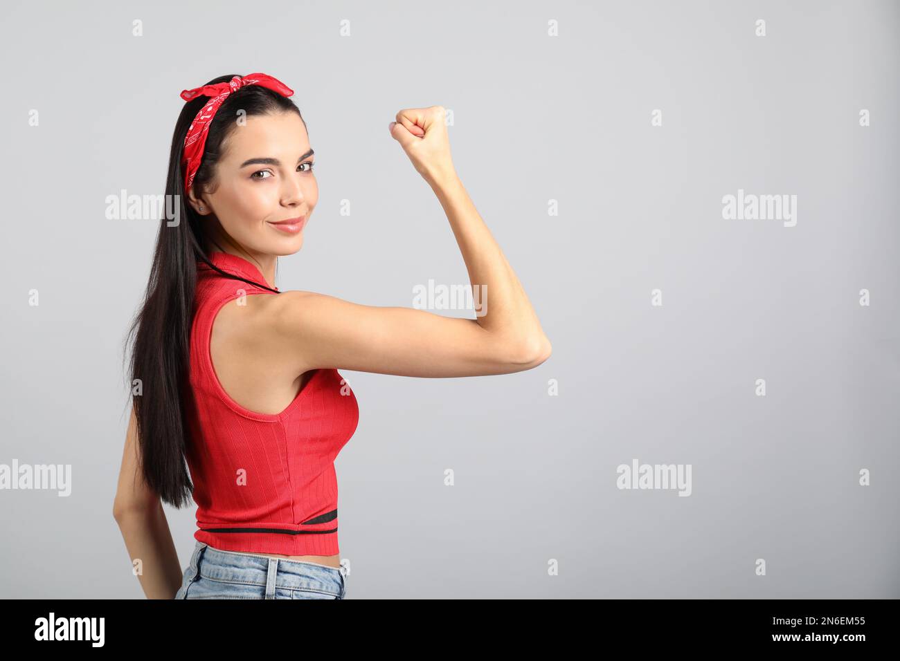 Strong woman as symbol of girl power on light grey background, space ...