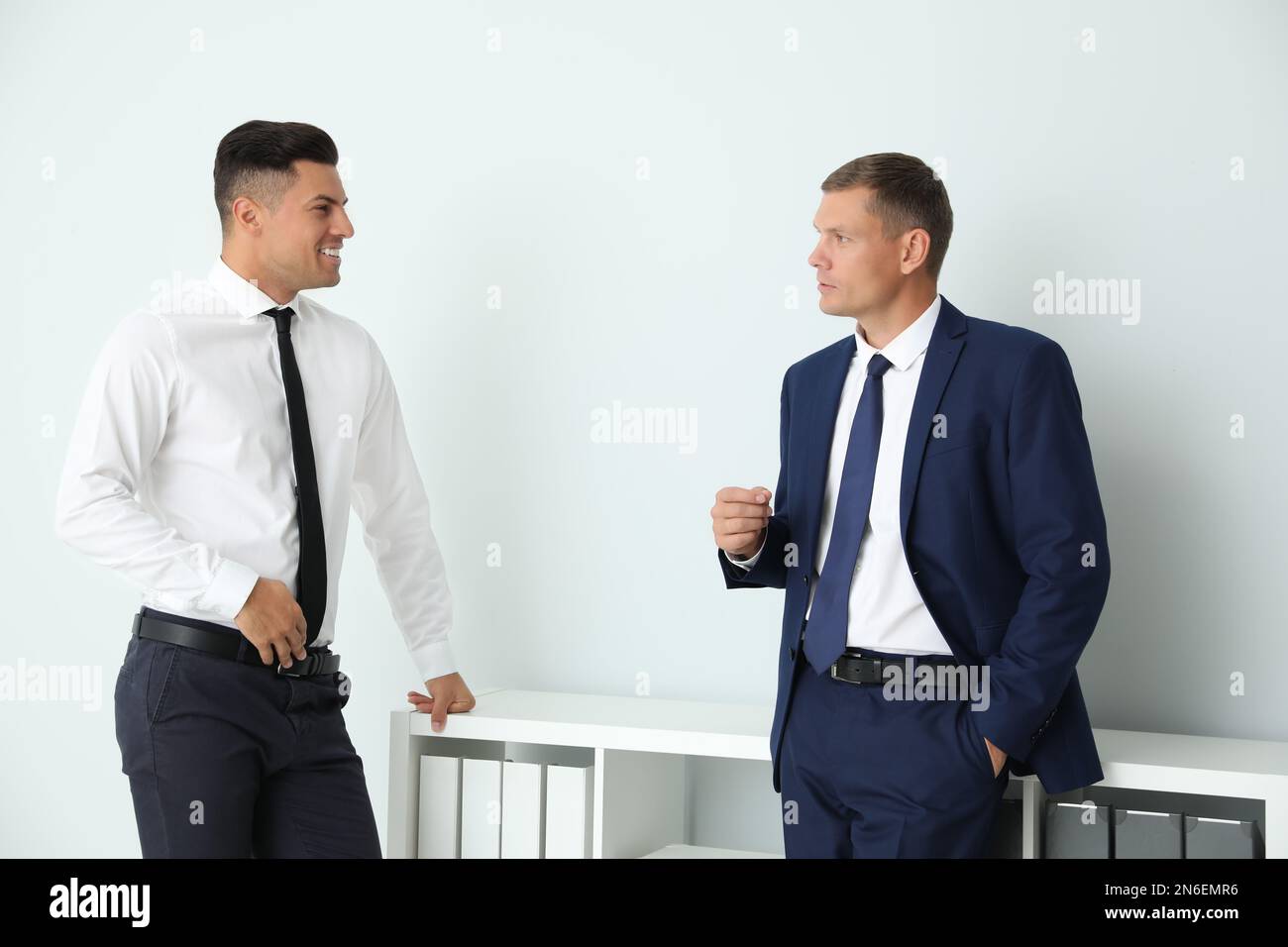 Smiling professional employees talking work hi-res stock photography ...