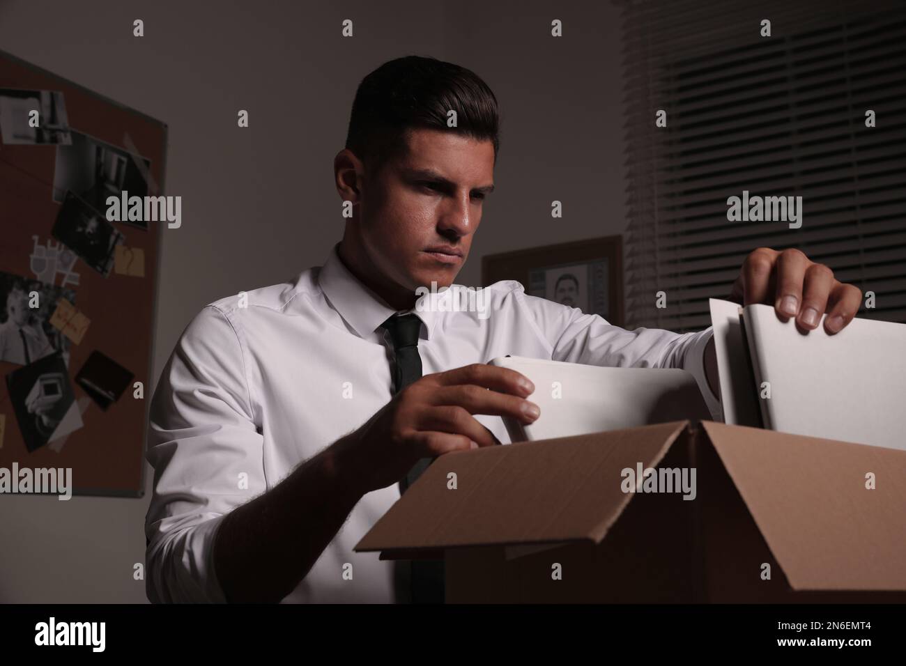 Professional detective doing paperwork in his office Stock Photo - Alamy