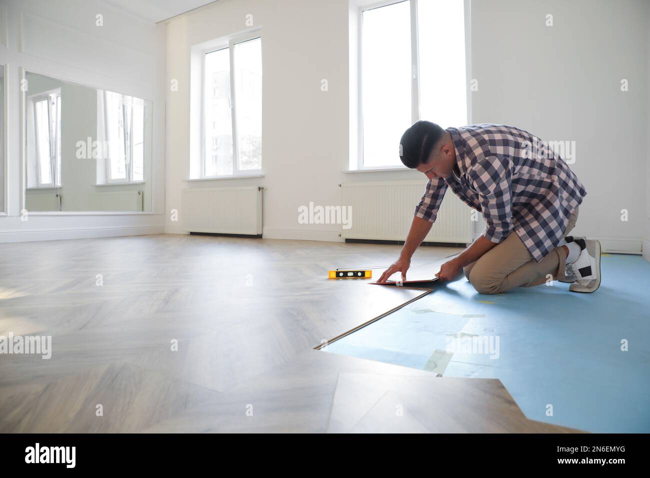 Professional worker installing new parquet flooring indoors Stock Photo ...