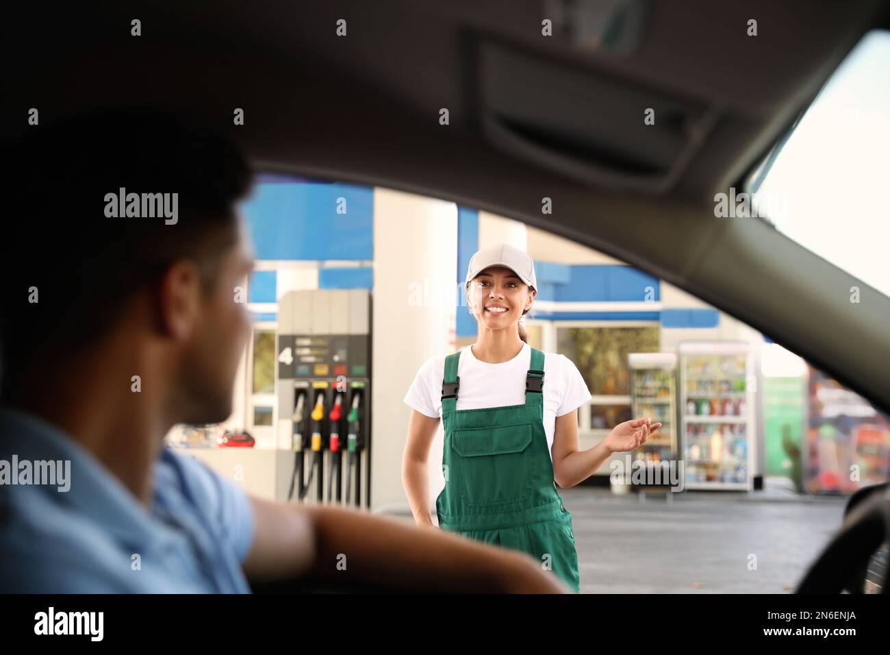 Man in car speaking with gas station worker Stock Photo - Alamy