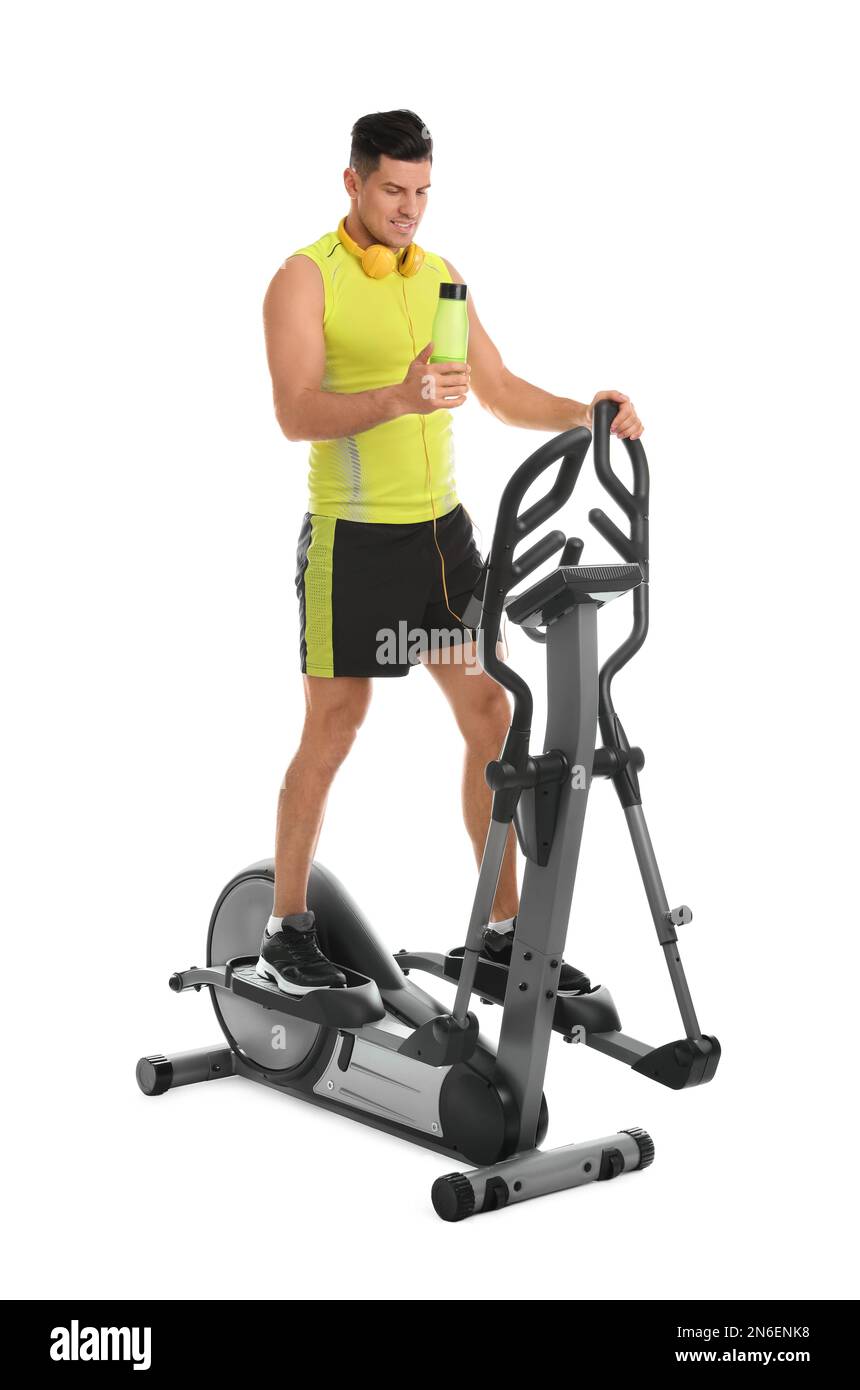 Man with bottle on modern elliptical machine against white background ...
