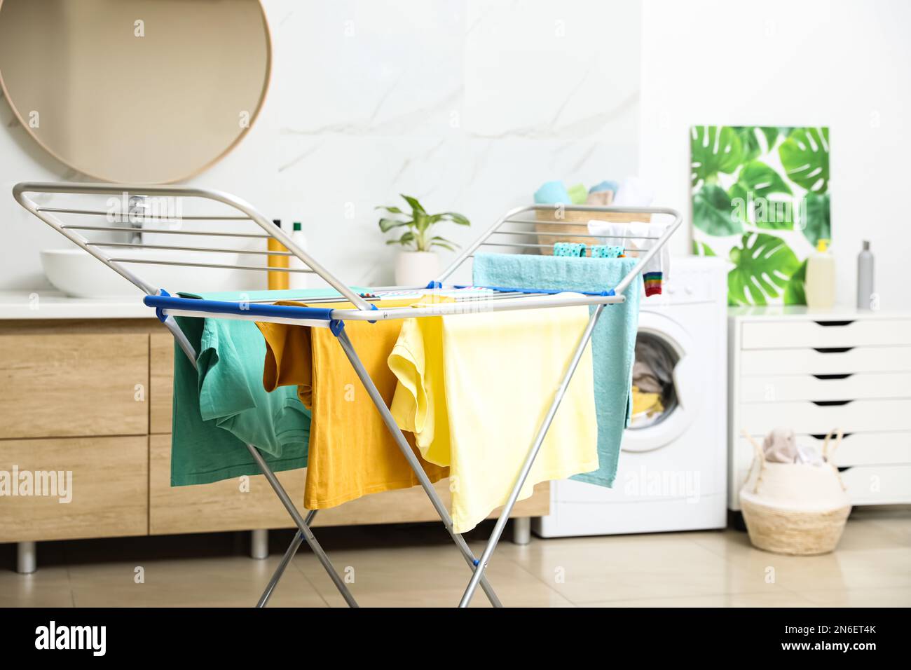 Clean laundry hanging on drying rack in bathroom Stock Photo - Alamy