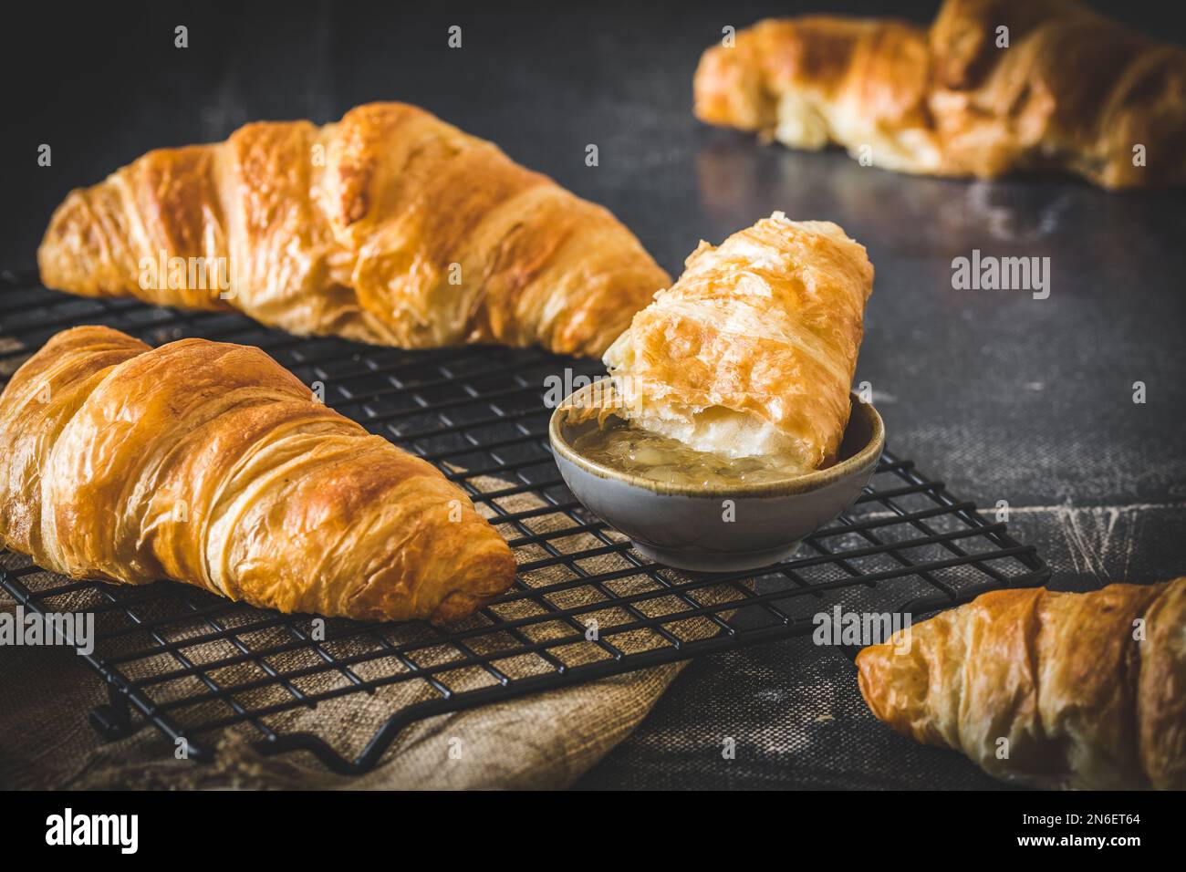 Fresh french croissants, one dipped in jam, black background Stock ...