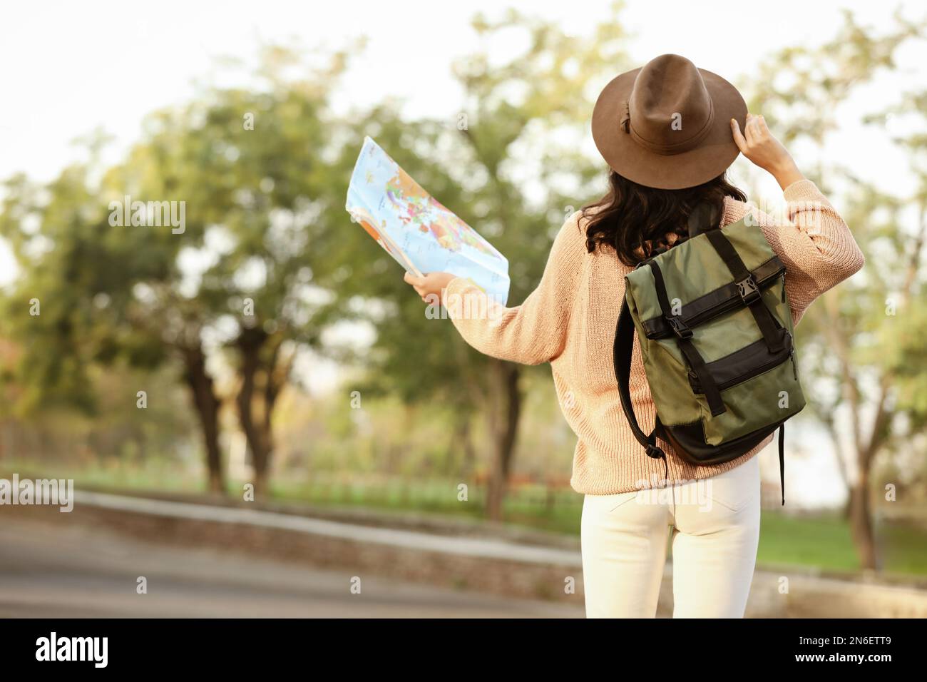 Traveler with map and backpack on city street, back view Stock Photo ...