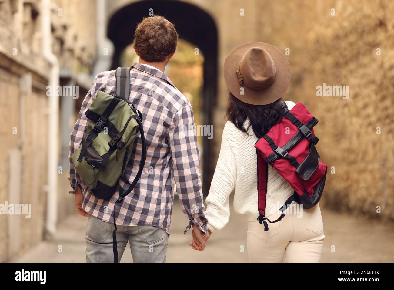 Couple of travelers with backpacks on city street, back view Stock ...