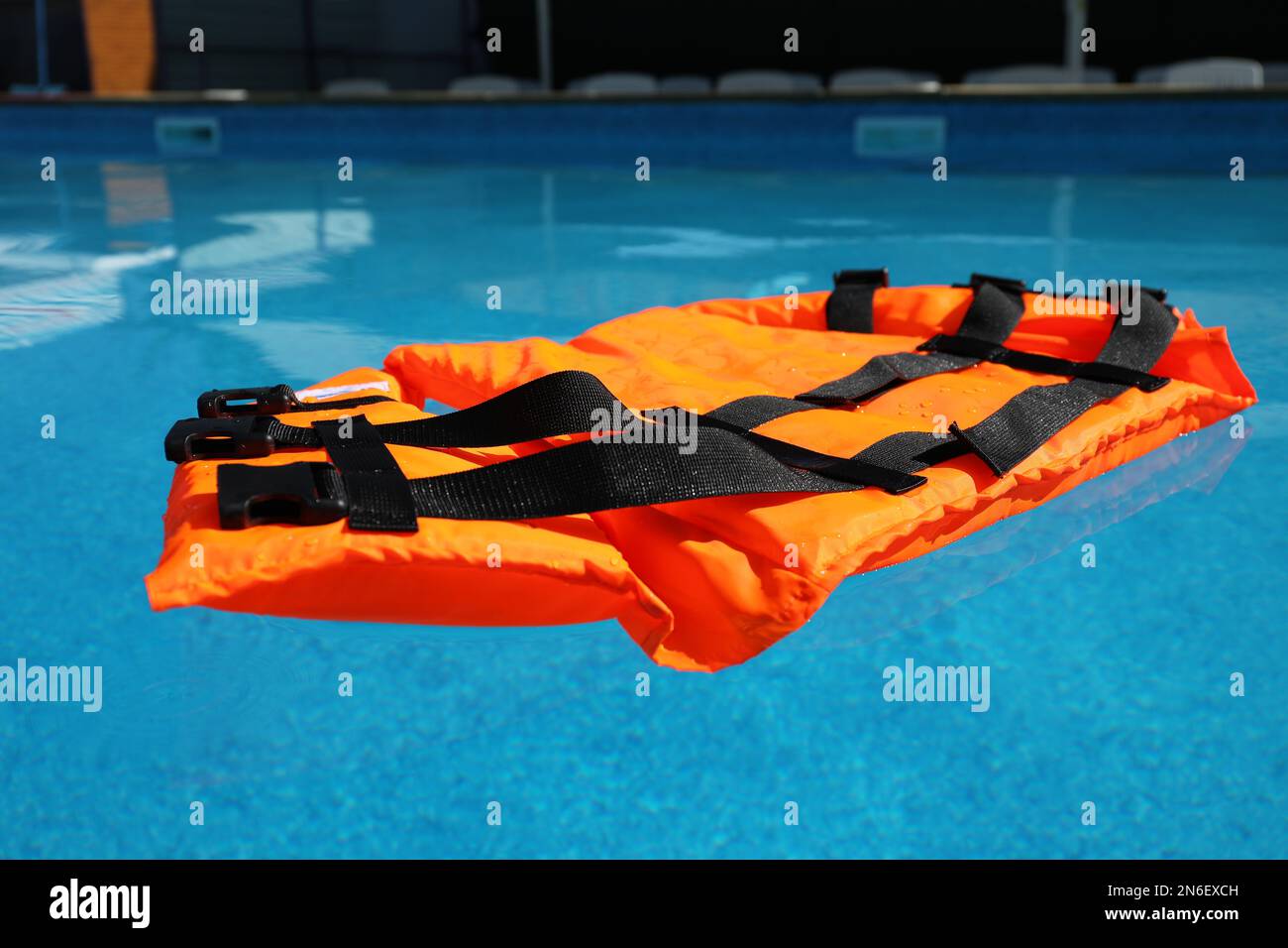Bright orange life jacket floating in swimming pool Stock Photo - Alamy
