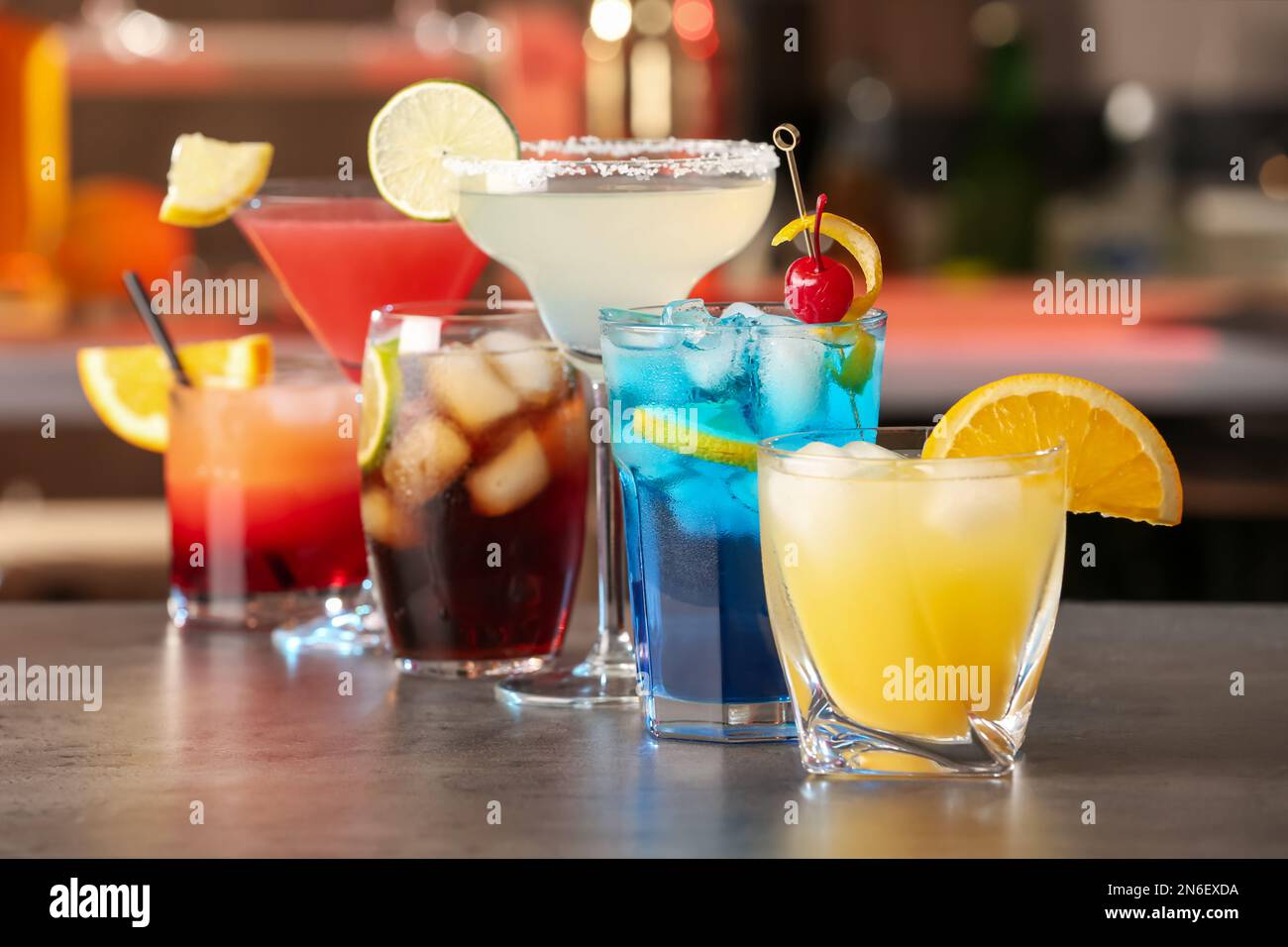 Different delicious cocktails on grey table in bar Stock Photo - Alamy
