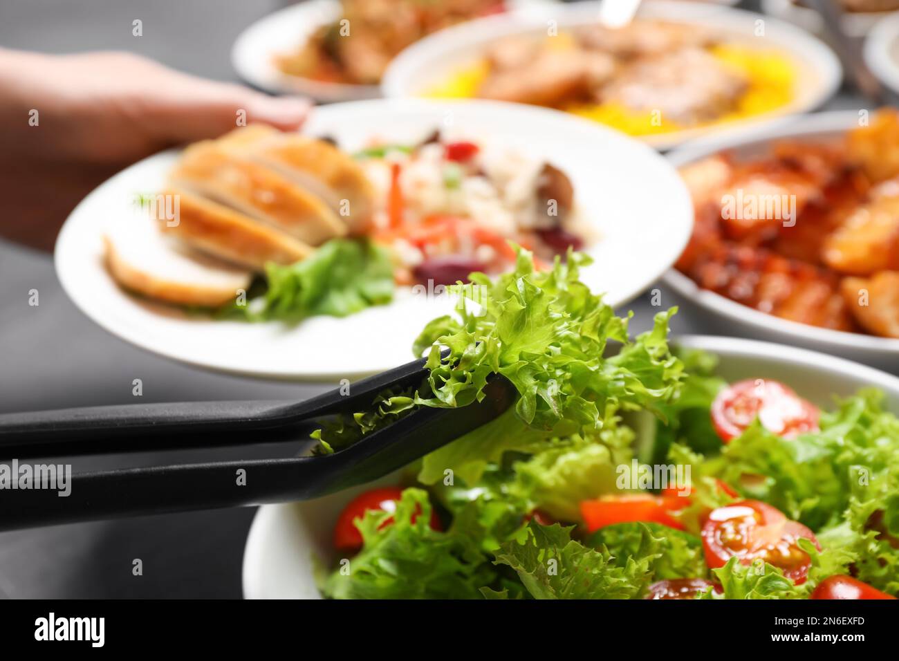 Woman taking food from buffet table, closeup Stock Photo - Alamy