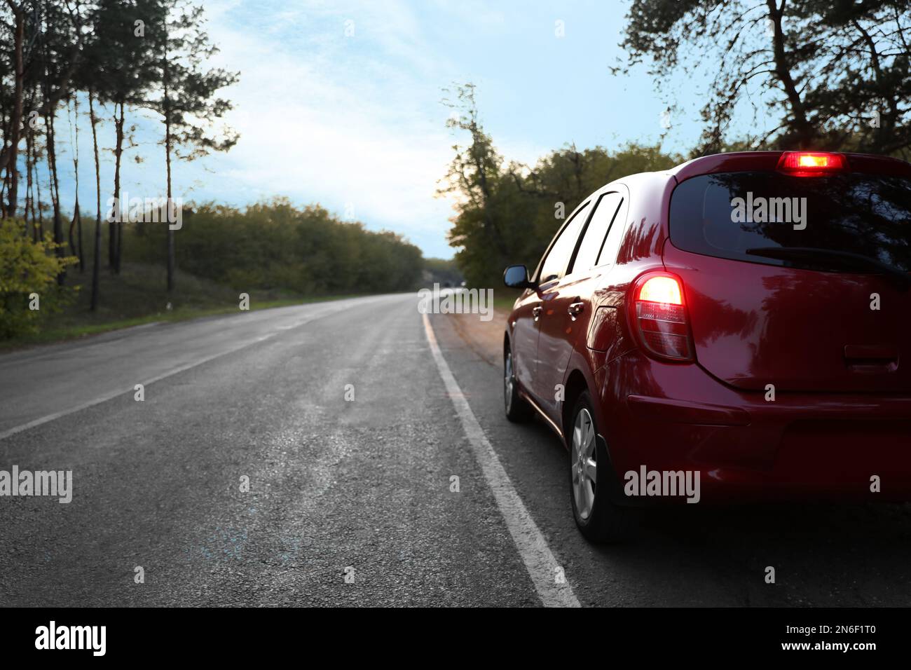 Red car parked near forest, back view. Road trip Stock Photo - Alamy