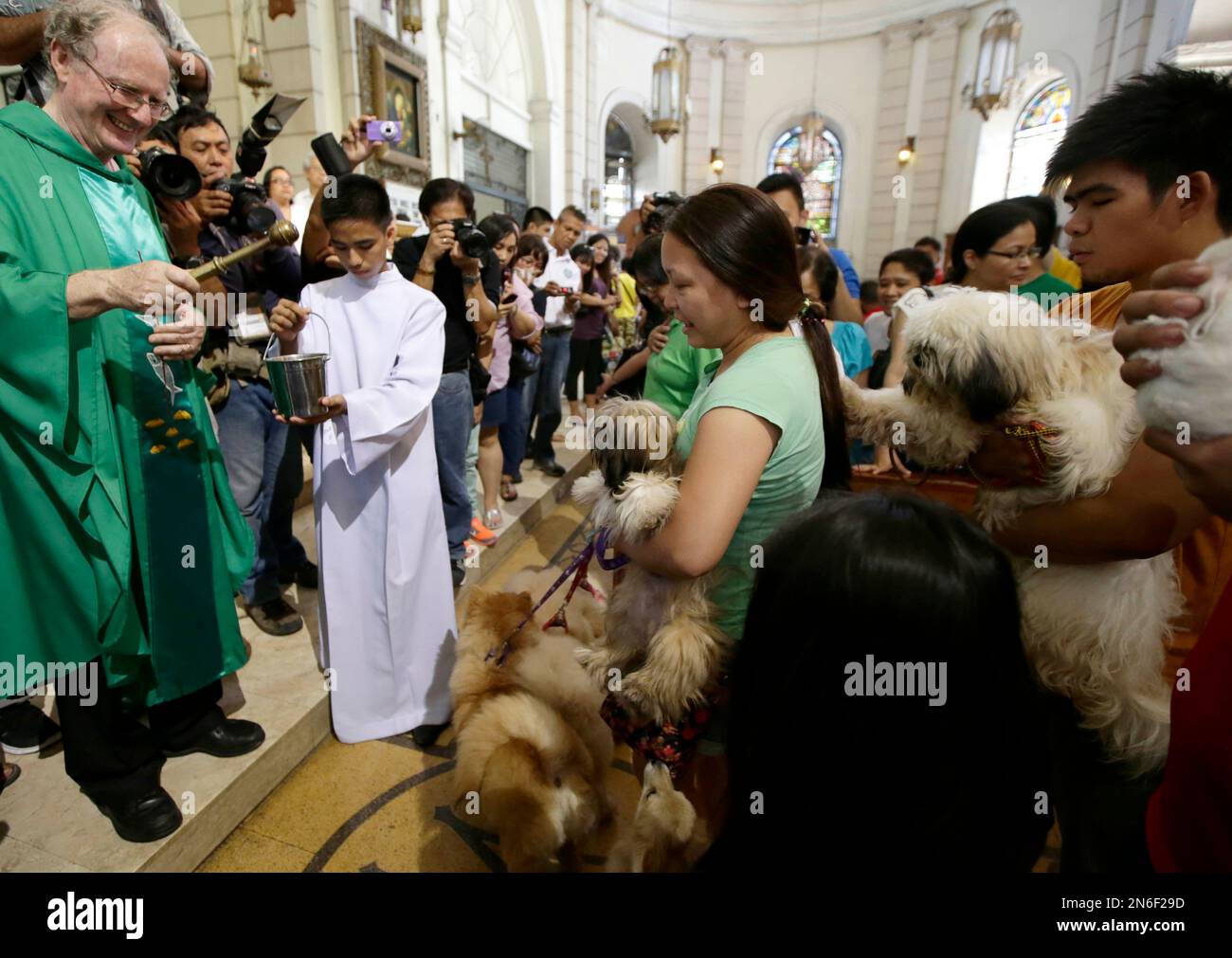 Roman Catholic devotees queue up to have their pets blessed by a ...