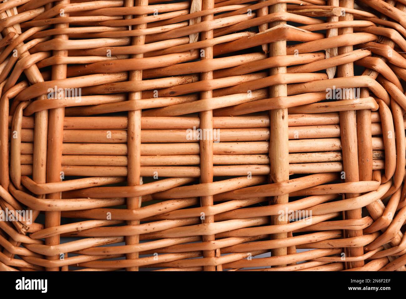 Handmade wicker basket made of natural material as background, closeup ...