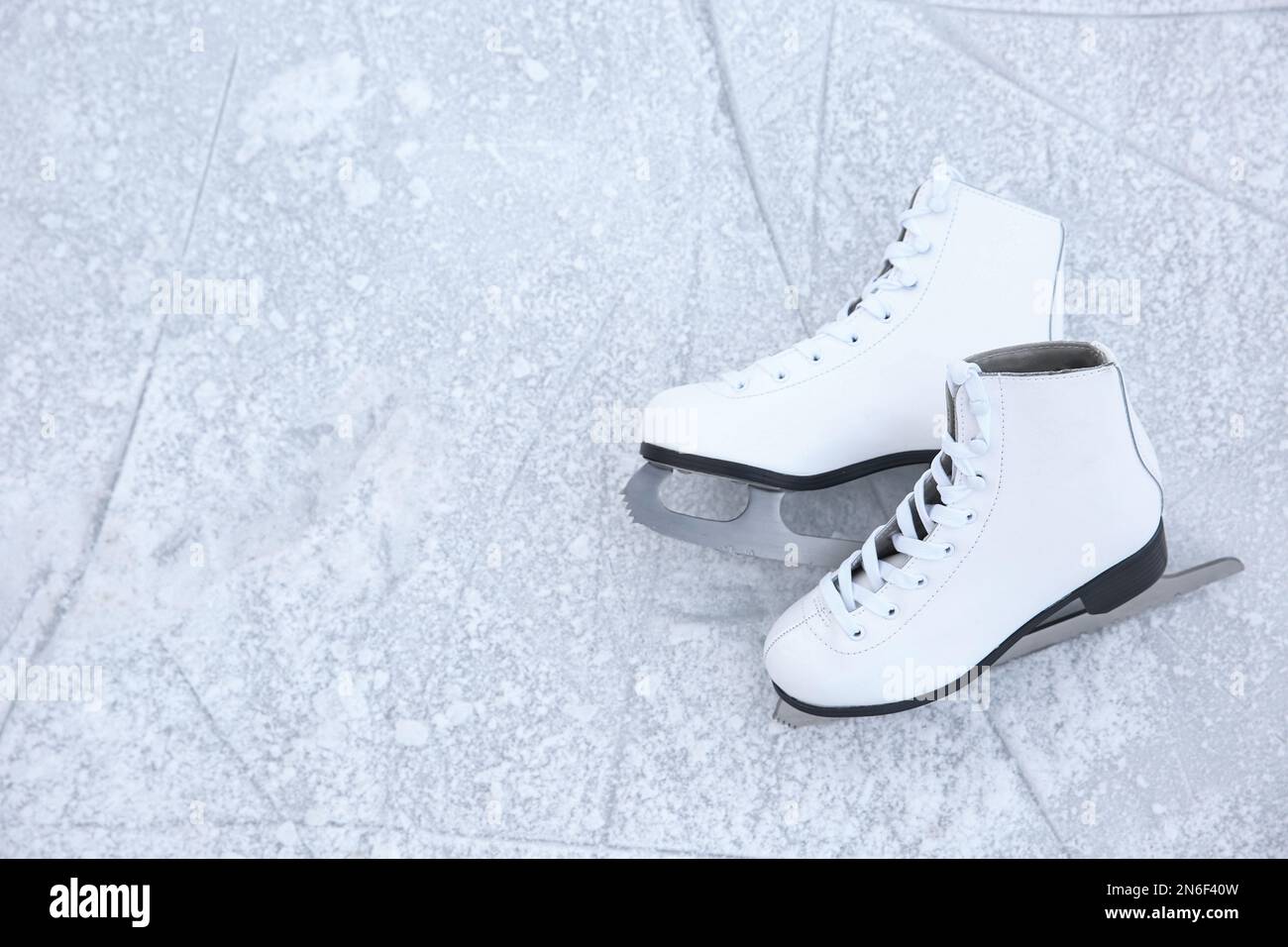 Pair of figure skates on ice, top view with space for text. Winter ...
