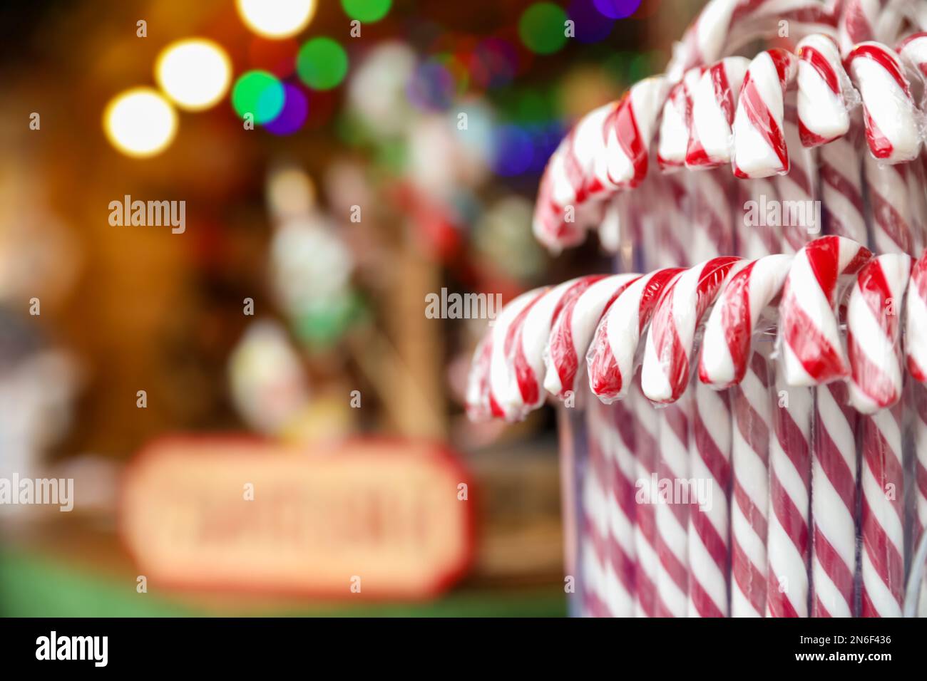 Candy canes on Christmas fair stall display, closeup. Space for text ...