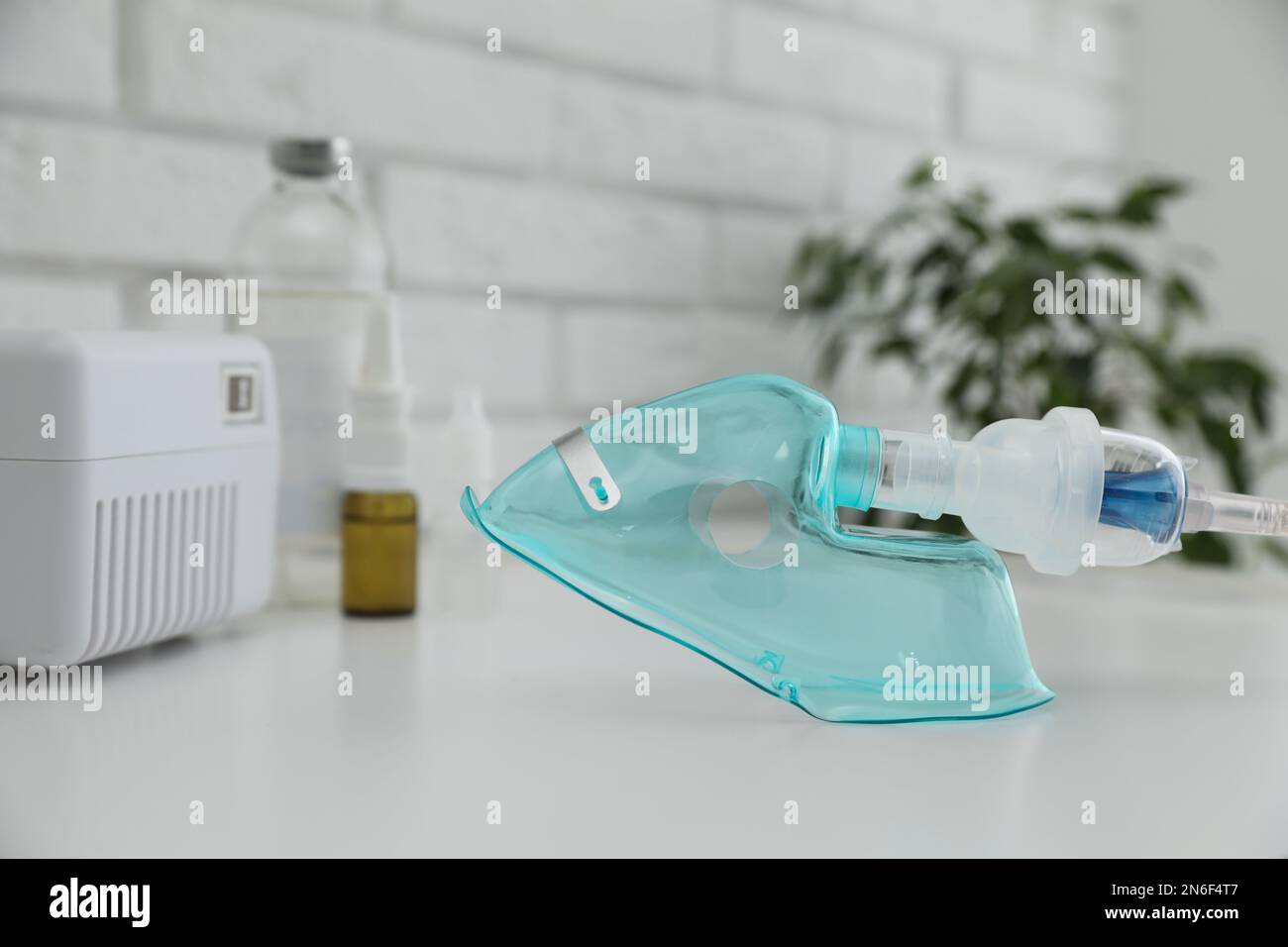 Face mask of modern nebulizer on white table. Equipment for inhalation ...