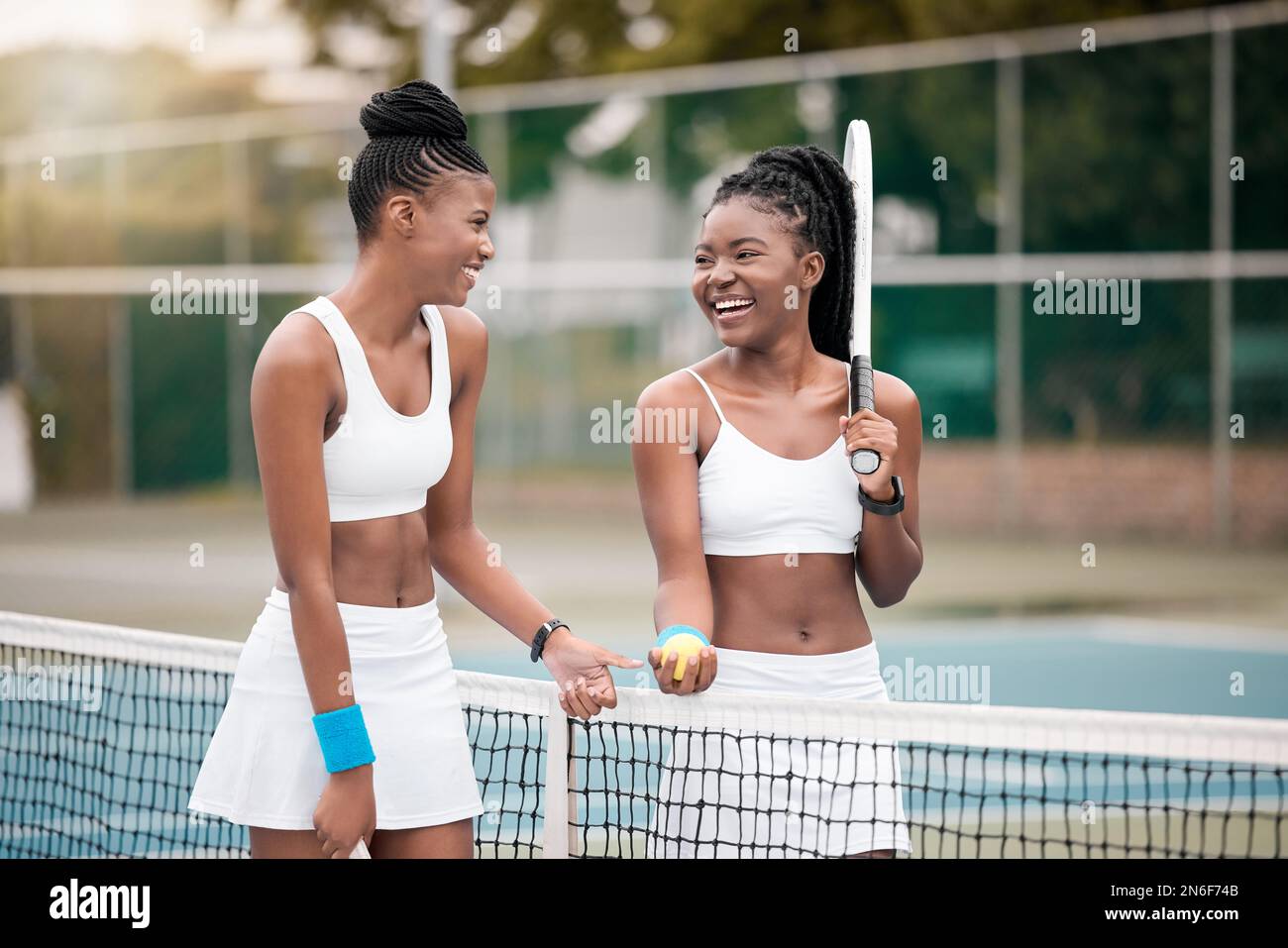 Two friends talking and laughing after a tennis match. Young women ...