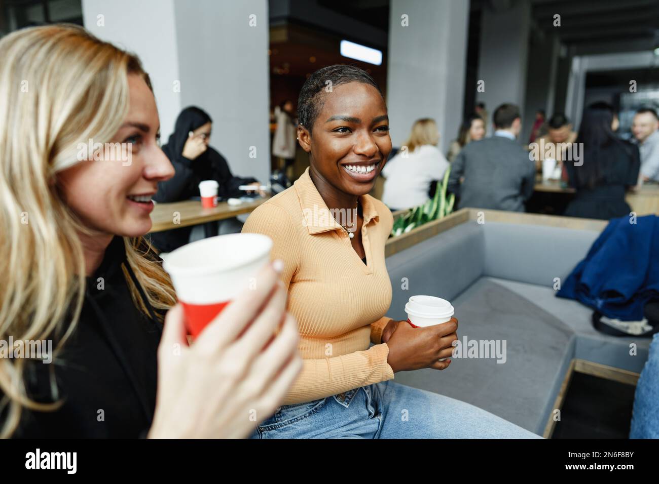 Two young women friends enjoying coffee together in a coffee shop Stock ...