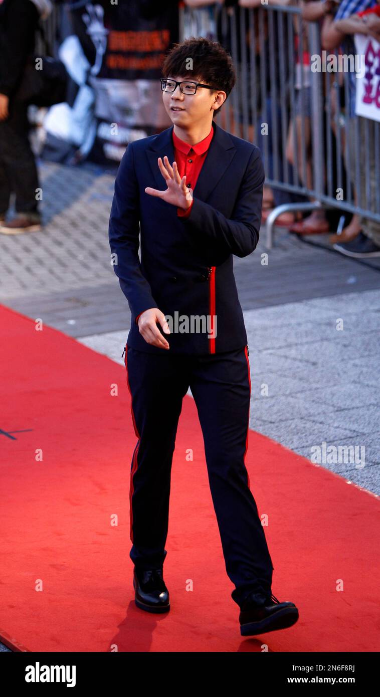 Chinese singer Hu Xia waves to his fans as he arrives on the red carpet ...