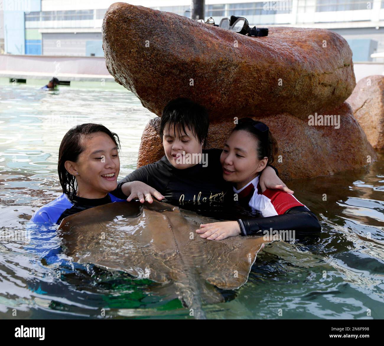 A Filipino disabled child touches a stingray during their interaction ...