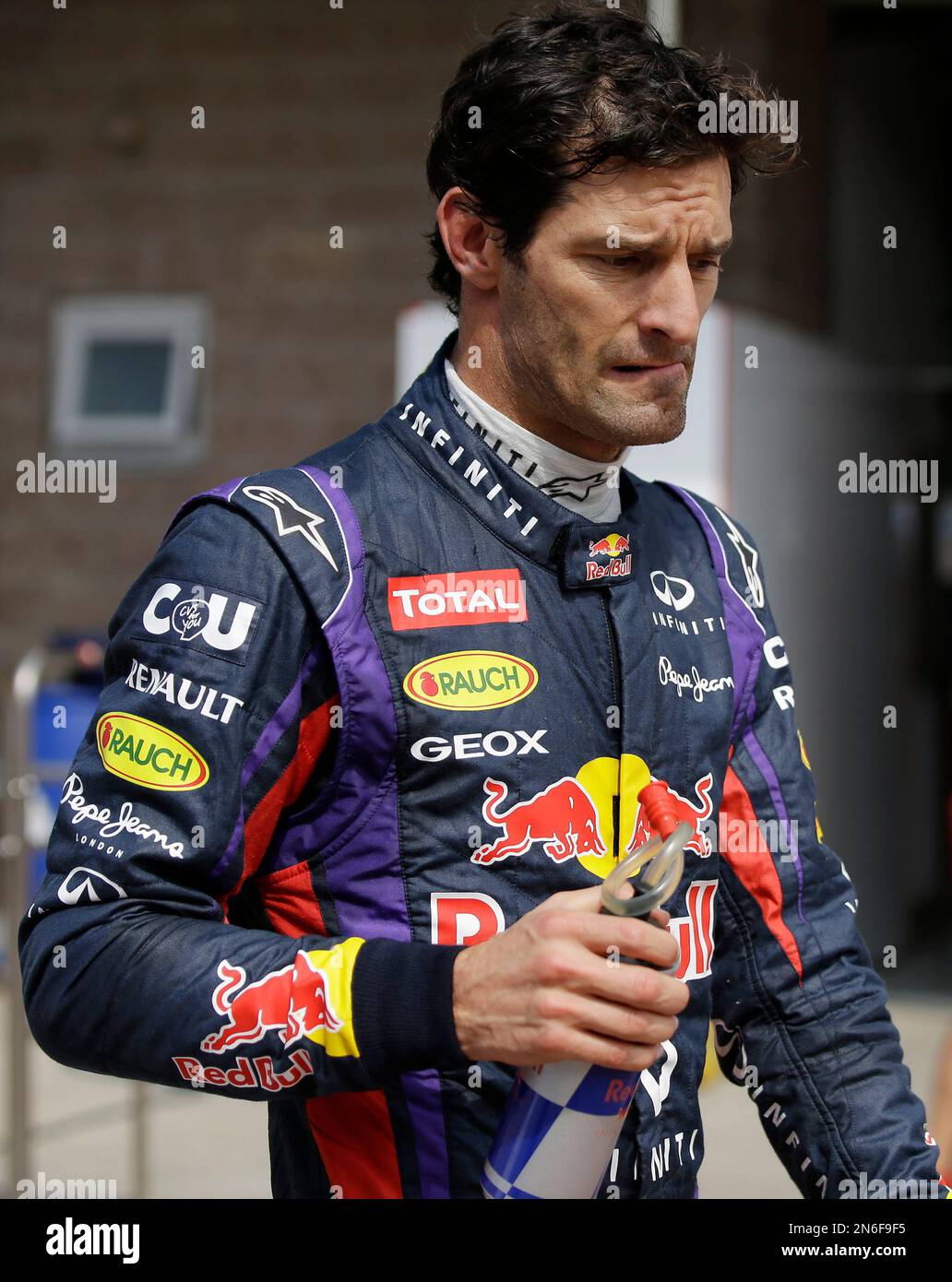 Red Bull driver Mark Webber of Australia walks down pit lane following the third practice ...