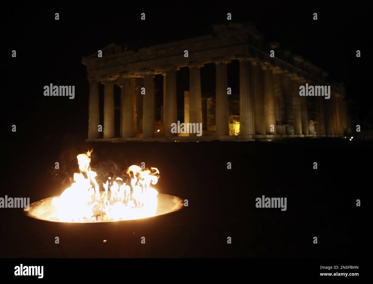 The Olympic Flame burns in the cauldron in front of Parthenon temple ...