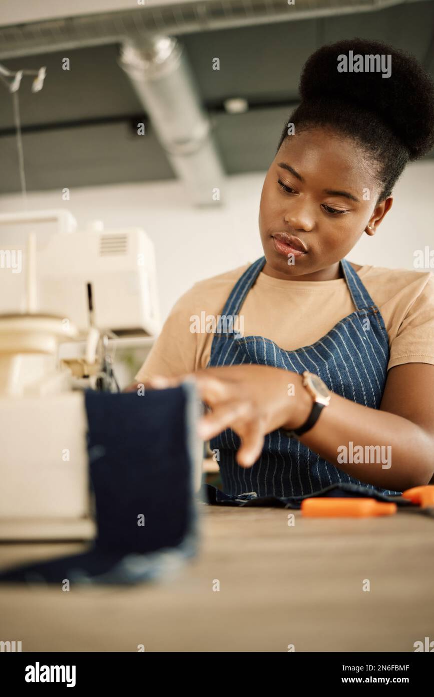 African american tailor sewing fabric. Young designer stitching denim ...