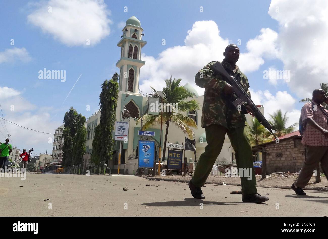 An armed Kenyan policeman patrols past the Masjid Musa Mosque, where ...