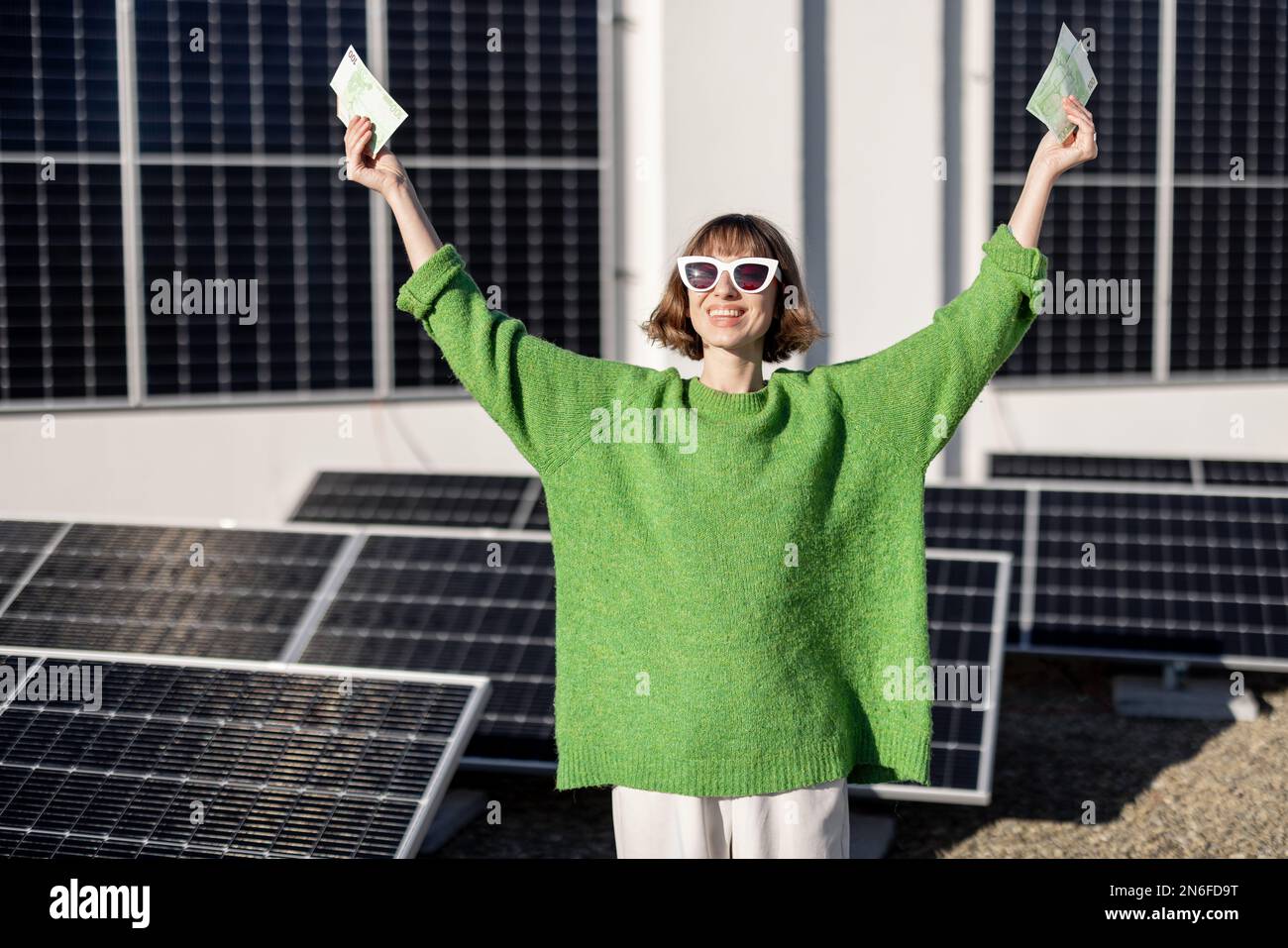 Happy household owner with money near solar power plant Stock Photo - Alamy