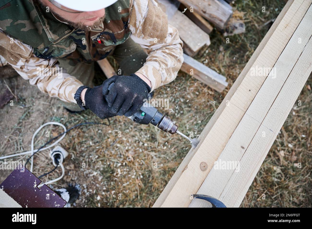 Man building wooden frame house on pile foundation. Close up of male ...