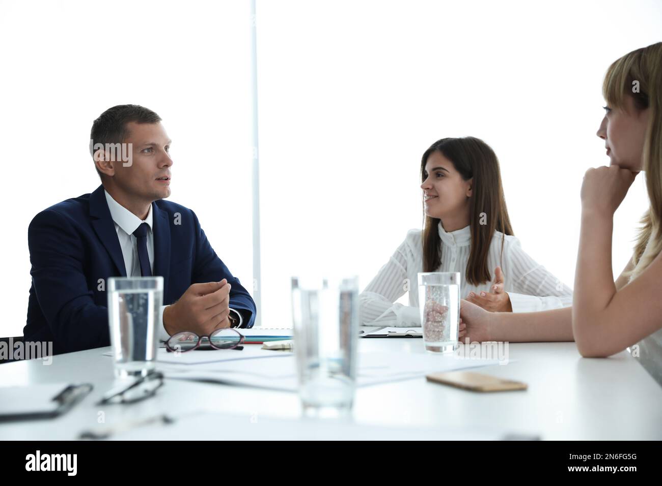 Office employees talking at table during meeting Stock Photo - Alamy