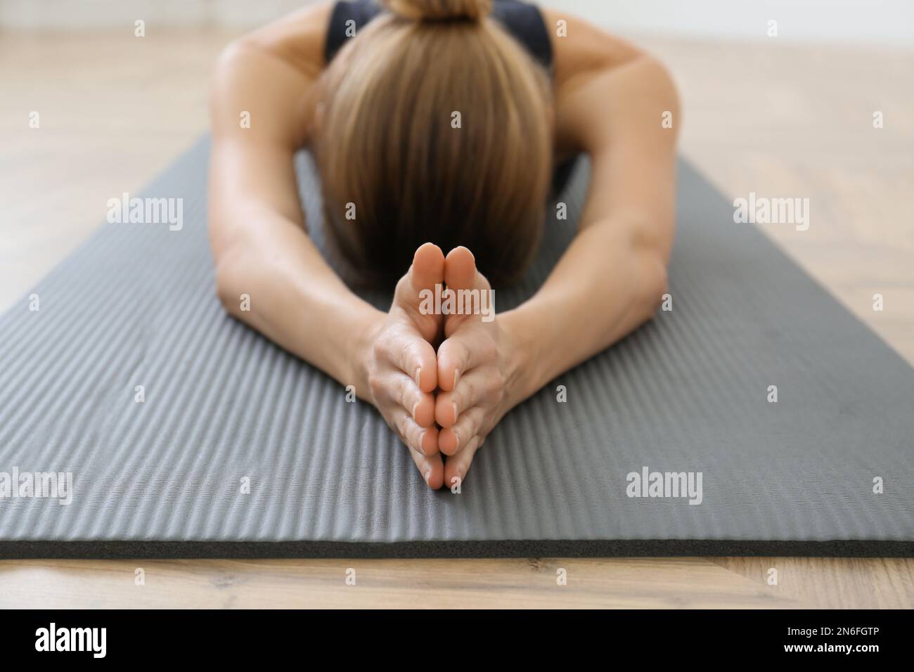 Young woman practicing extended child asana in yoga studio, focus on ...