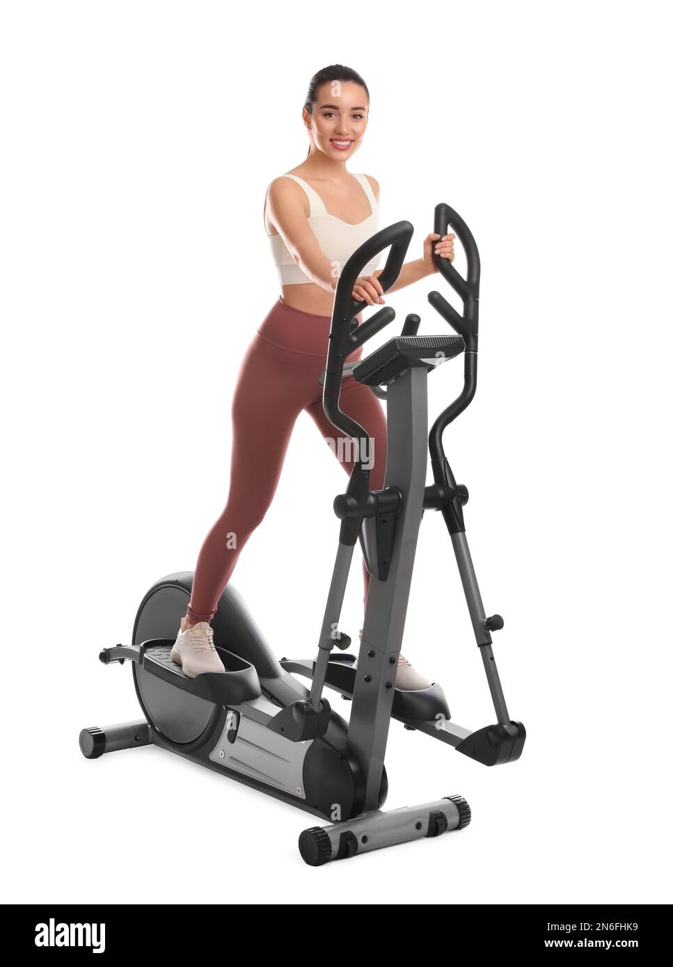 Woman using modern elliptical machine on white background Stock Photo ...