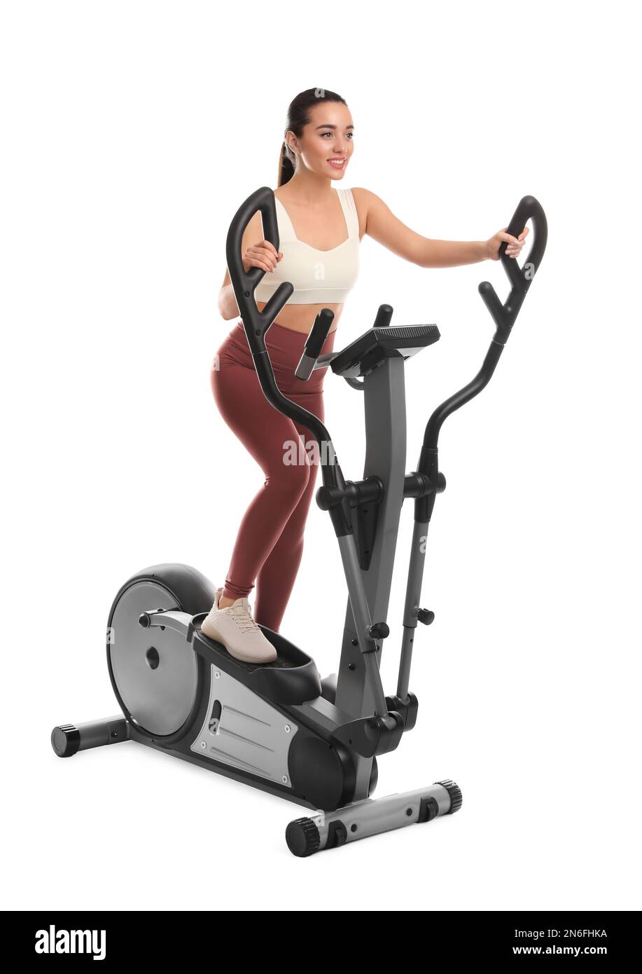 Woman using modern elliptical machine on white background Stock Photo ...