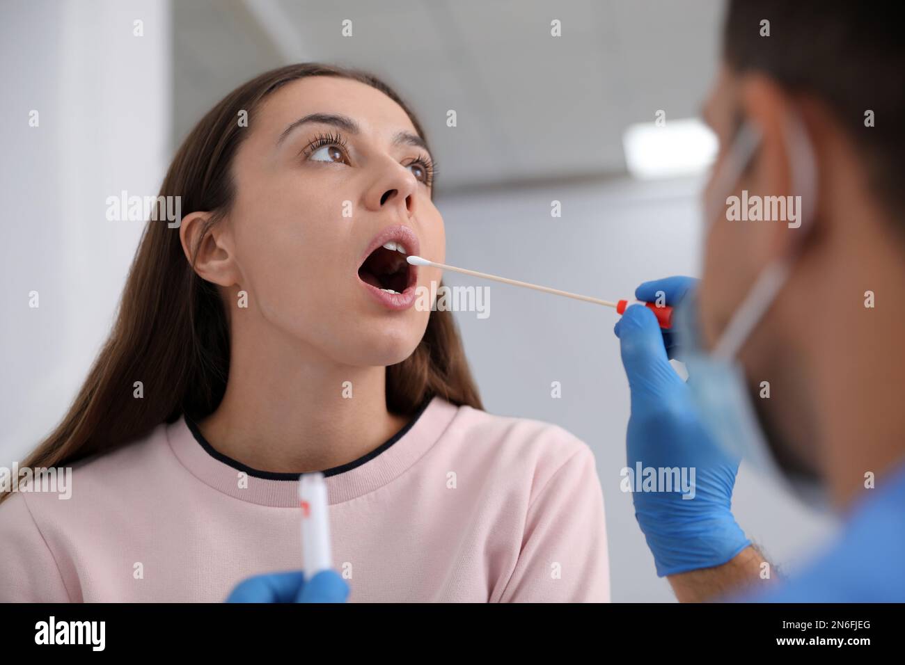 Doctor taking sample for DNA test from woman in clinic Stock Photo - Alamy