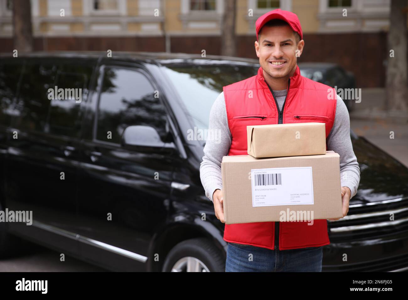 Courier with parcels near delivery van outdoors Stock Photo - Alamy