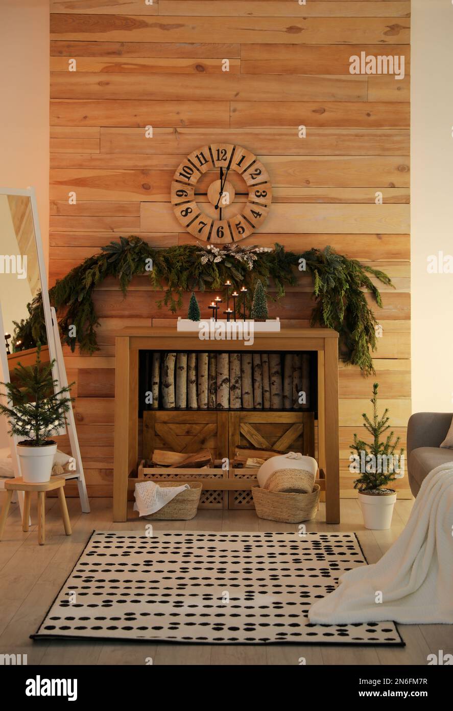 Cozy room interior with console table and conifer garland near wooden ...
