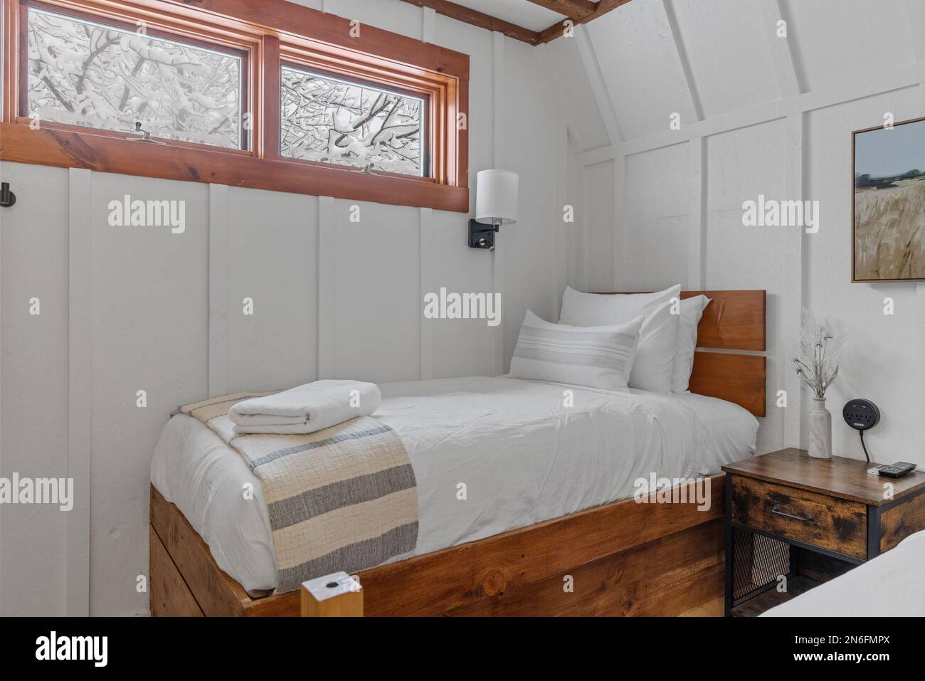 A small comfortable simple bedroom with one bed and white walls Stock ...