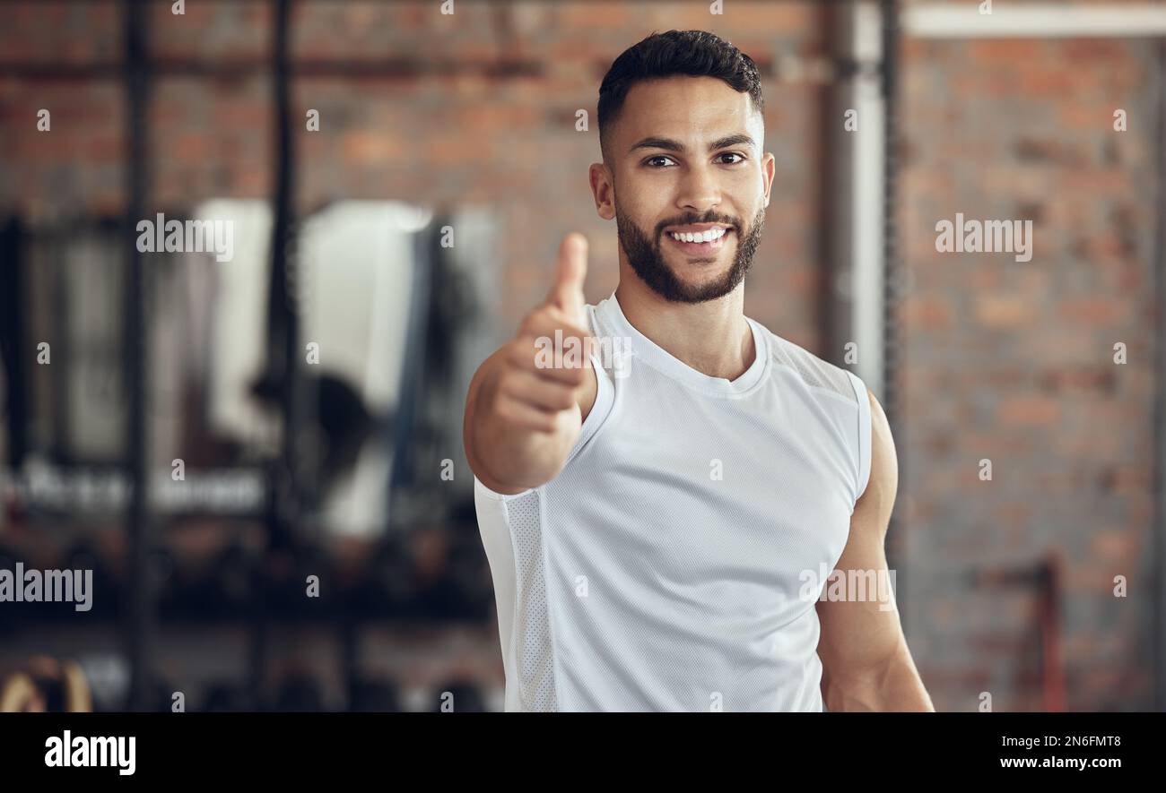 Portrait of young athlete giving thumbs up. Young fit man doing his ...
