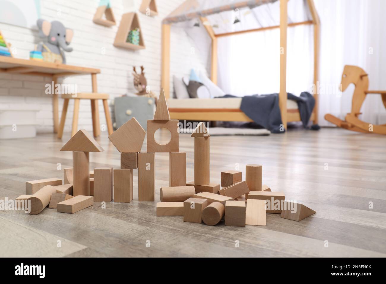 Wooden toy construction set on floor in playroom. Interior design Stock ...