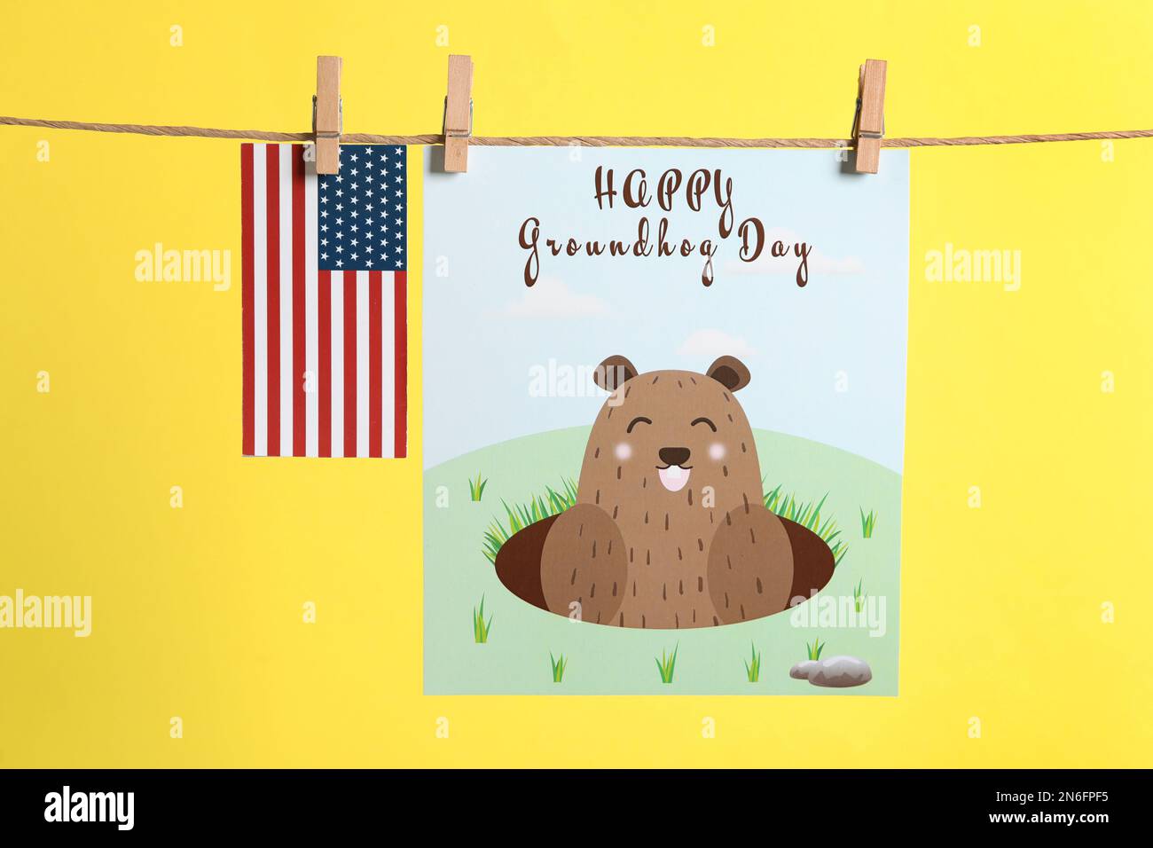 Happy Groundhog Day greeting card and American flag hanging on yellow ...