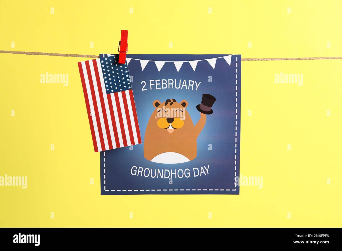 Happy Groundhog Day greeting card and American flag hanging on yellow ...
