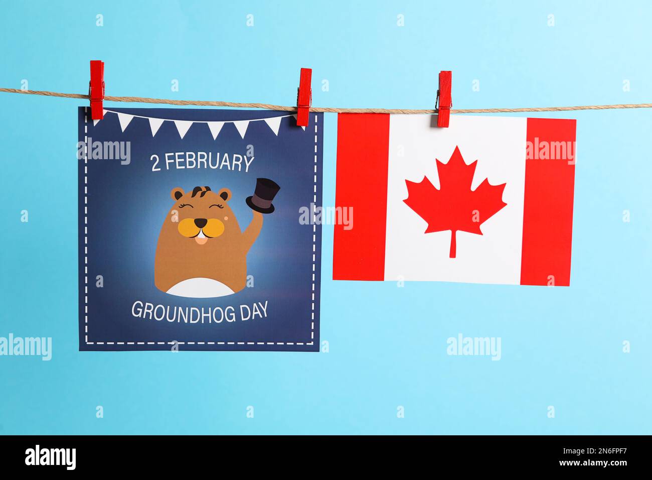 Happy Groundhog Day greeting card and Canada flag hanging on light blue ...