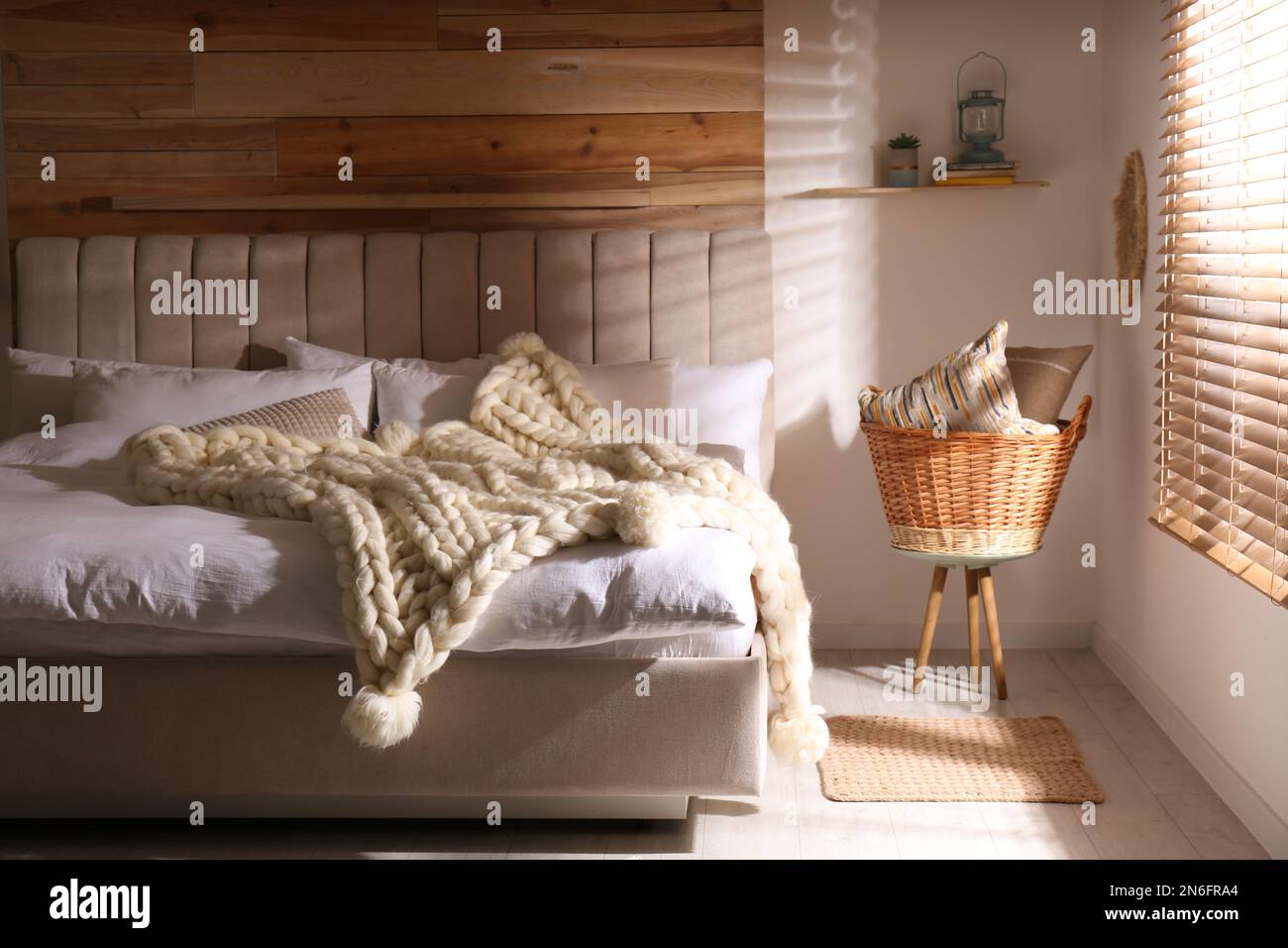 Bed with white knitted plaid in room. Interior design Stock Photo - Alamy
