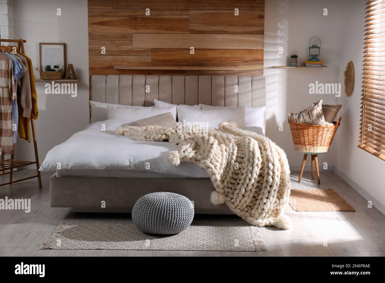 Bed with white knitted plaid in room. Interior design Stock Photo - Alamy