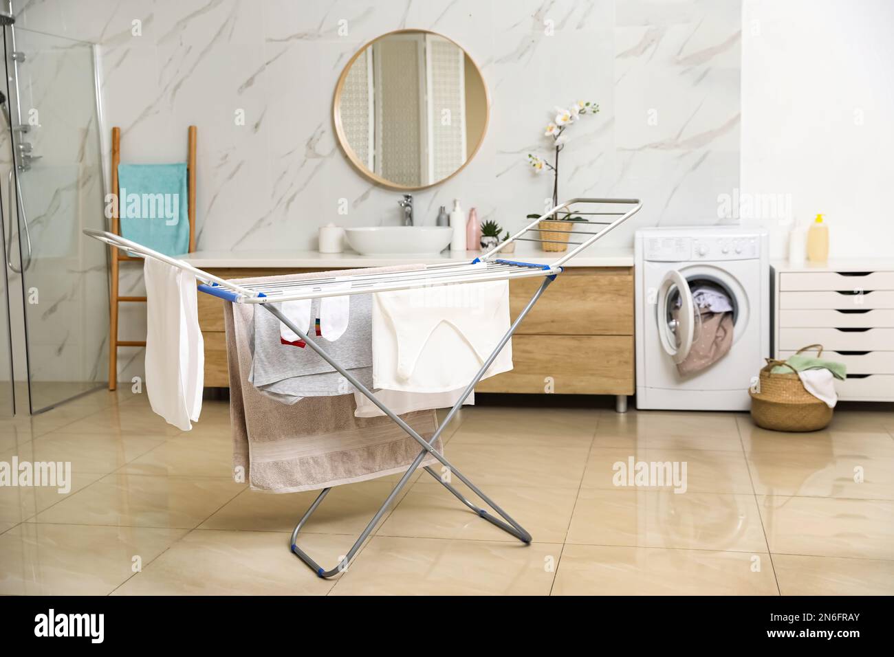 Clean laundry hanging on drying rack in bathroom Stock Photo - Alamy
