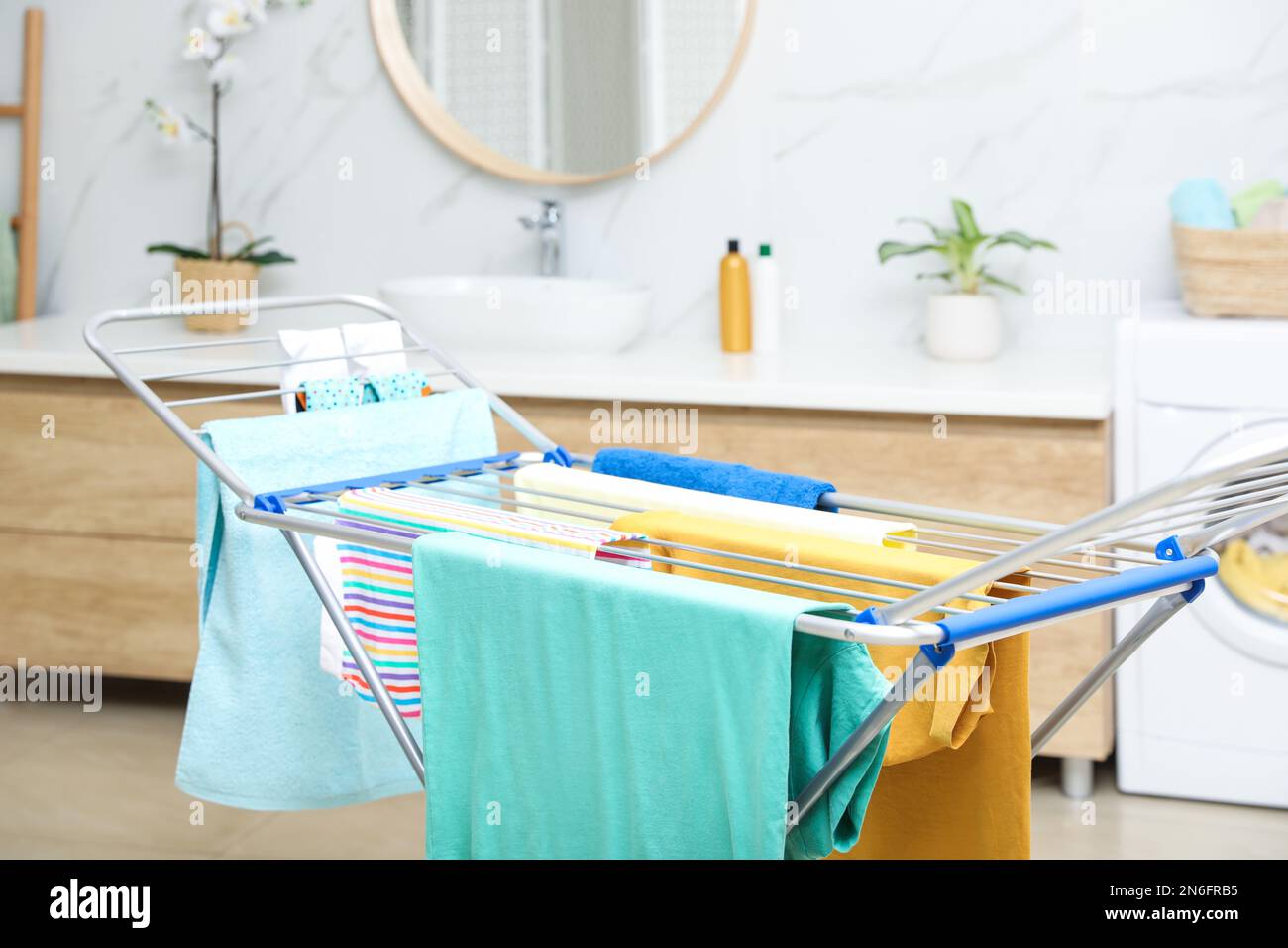 Clean laundry hanging on drying rack in bathroom Stock Photo - Alamy