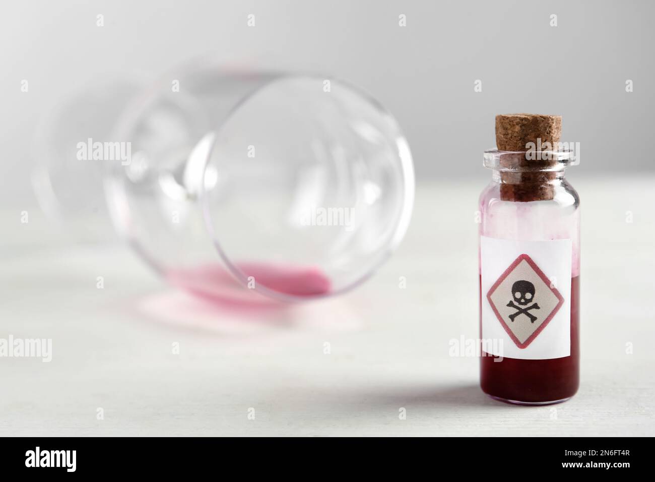 Vial of poison and partially emptied glass on light background Stock ...