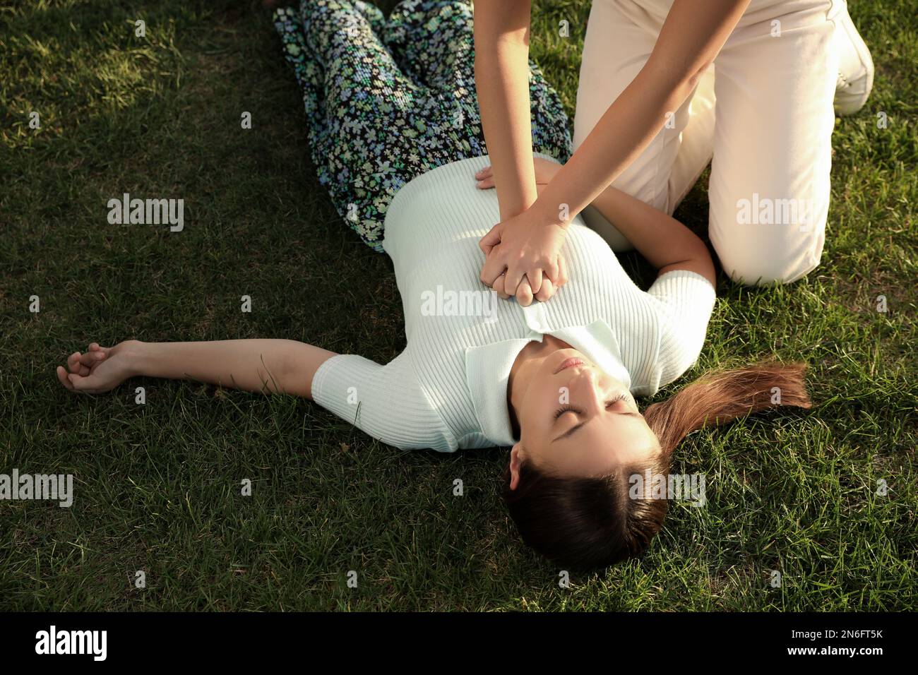 Woman doing cardiac massage to unconscious person with heart attack on ...