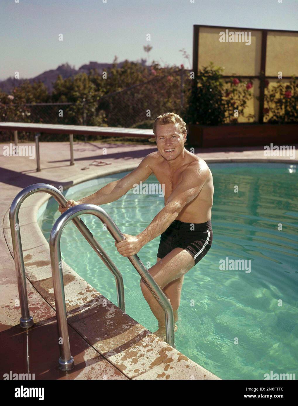 Actor John Smith standing in swimming pool at home in Hollywood, Calif ...