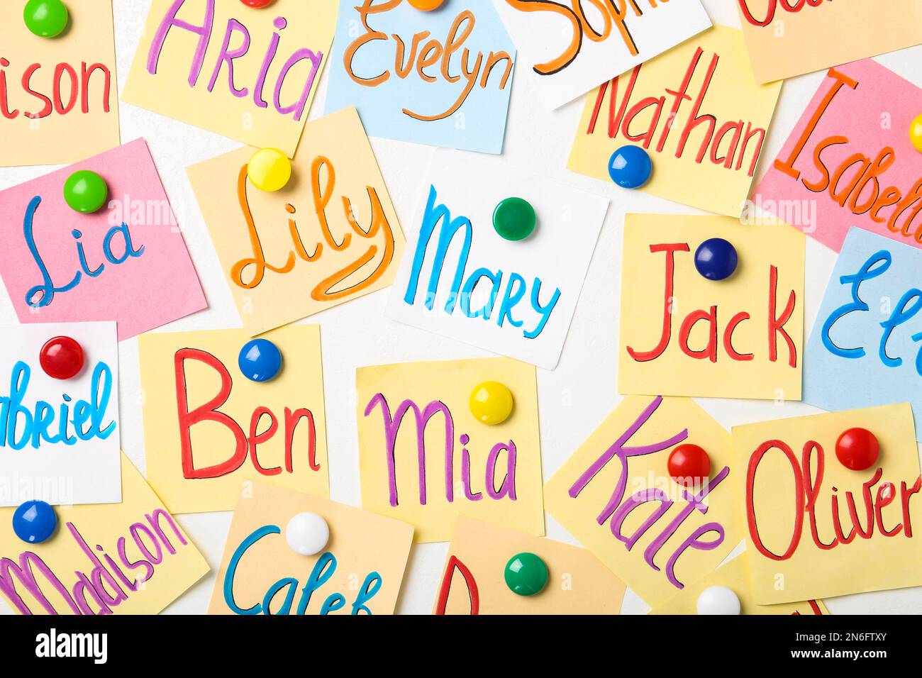 Colorful paper sheets with written different baby names on white ...